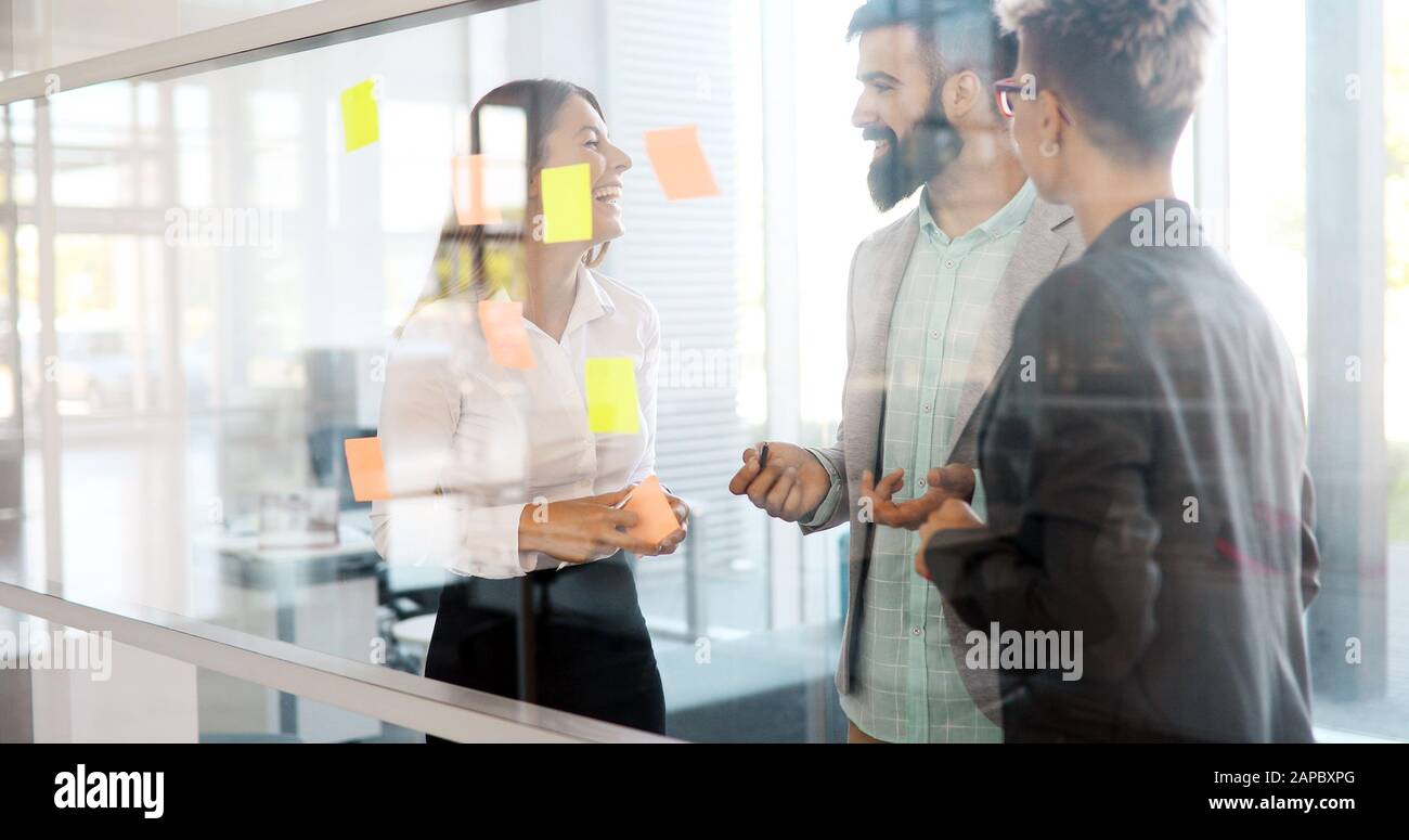 Picture of designers sticking notes in office Stock Photo - Alamy