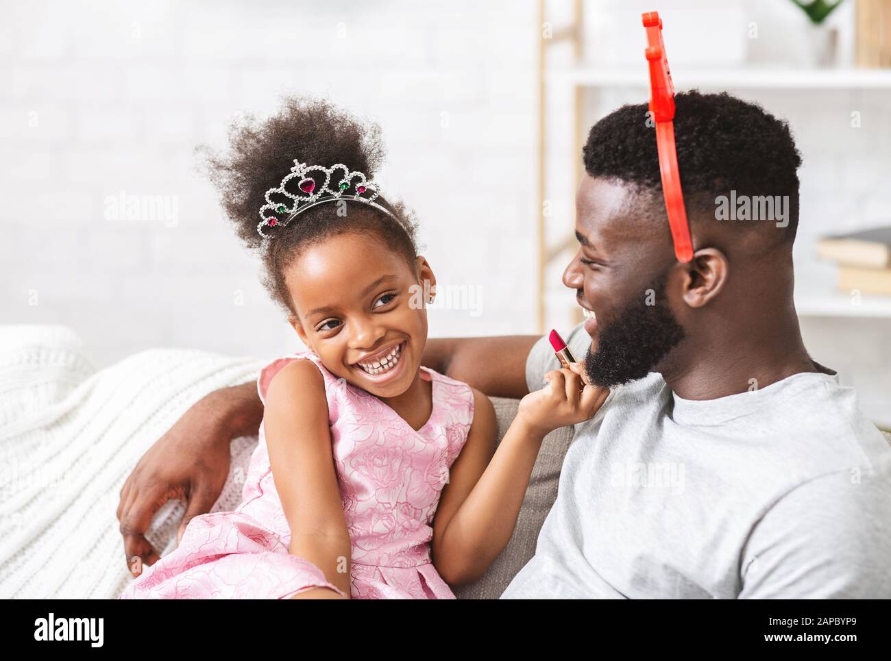 Little cute princess putting make up on her father Stock Photo - Alamy
