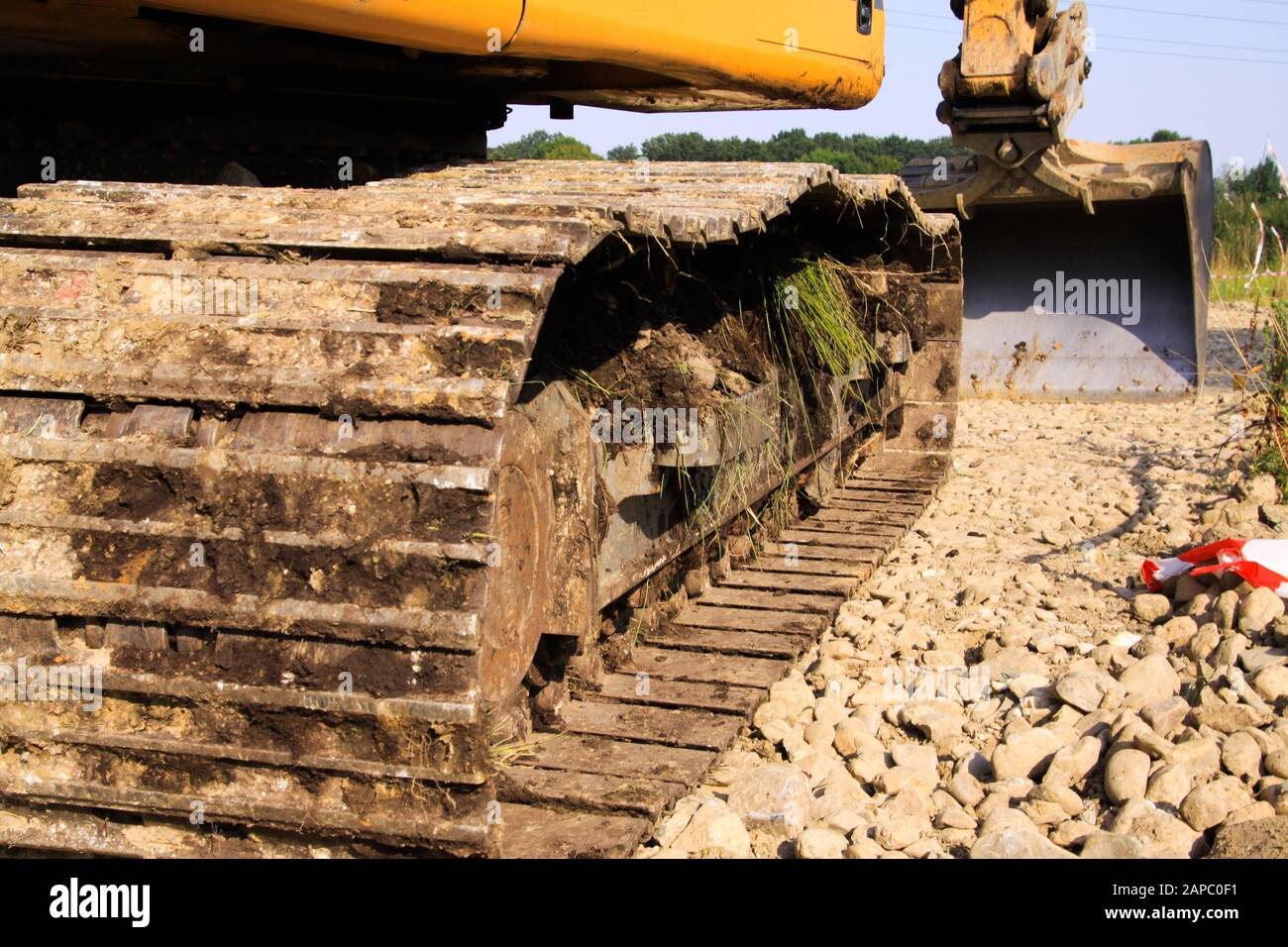 View along crawler drive chassis of dirty excavator on shovel with ...