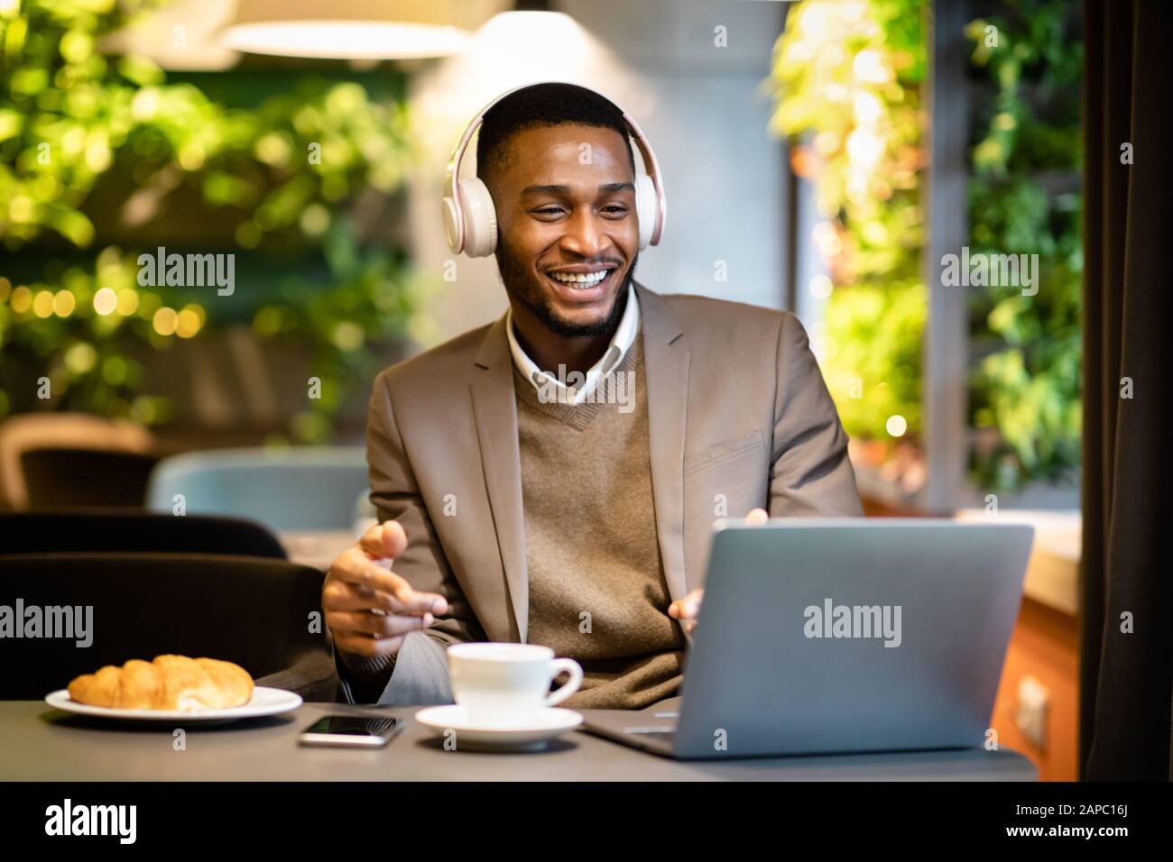 Portrait of afro guy using computer listening to music Stock Photo - Alamy