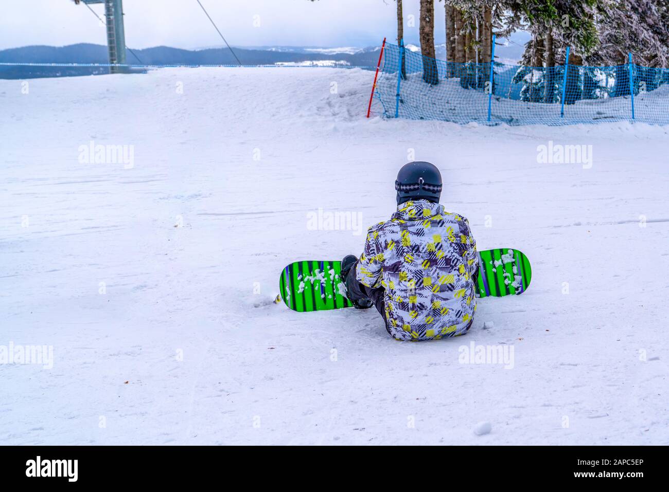 Back view of snowboarder sitting and relaxing Stock Photo - Alamy
