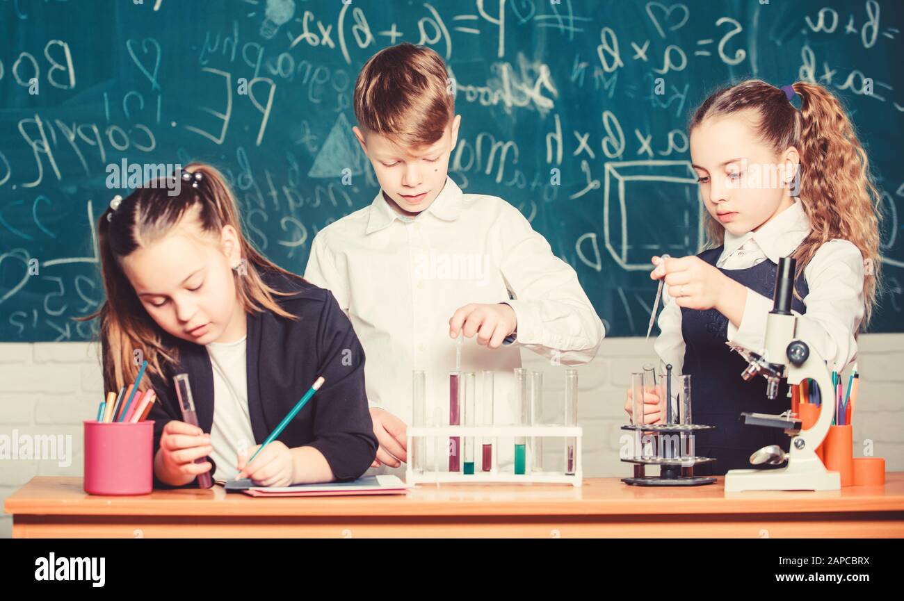 students doing biology experiments with microscope. Little children at ...