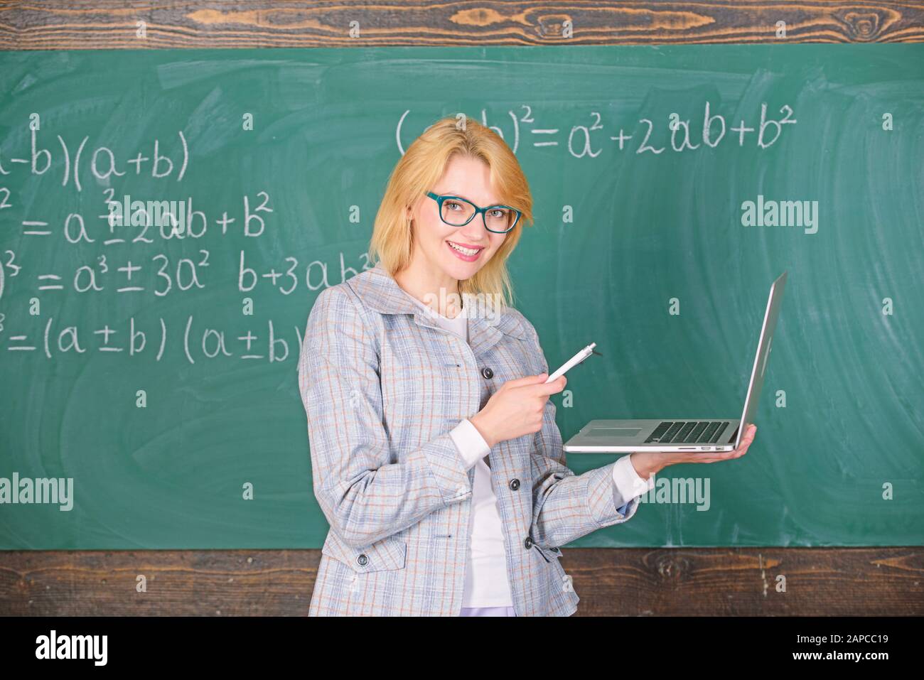 Educator smart lady with modern laptop surfing internet chalkboard ...