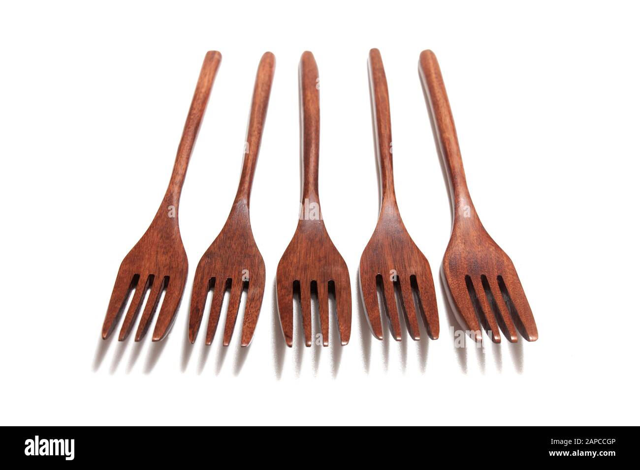 Close view of wooden forks over a white background Stock Photo - Alamy