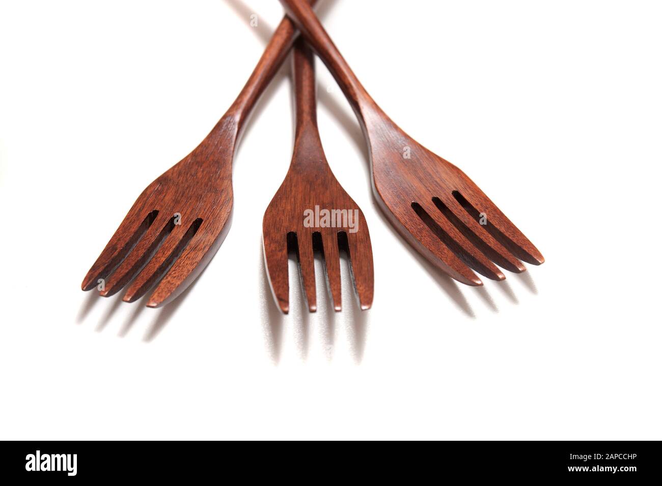 Close view of wooden forks over a white background Stock Photo - Alamy