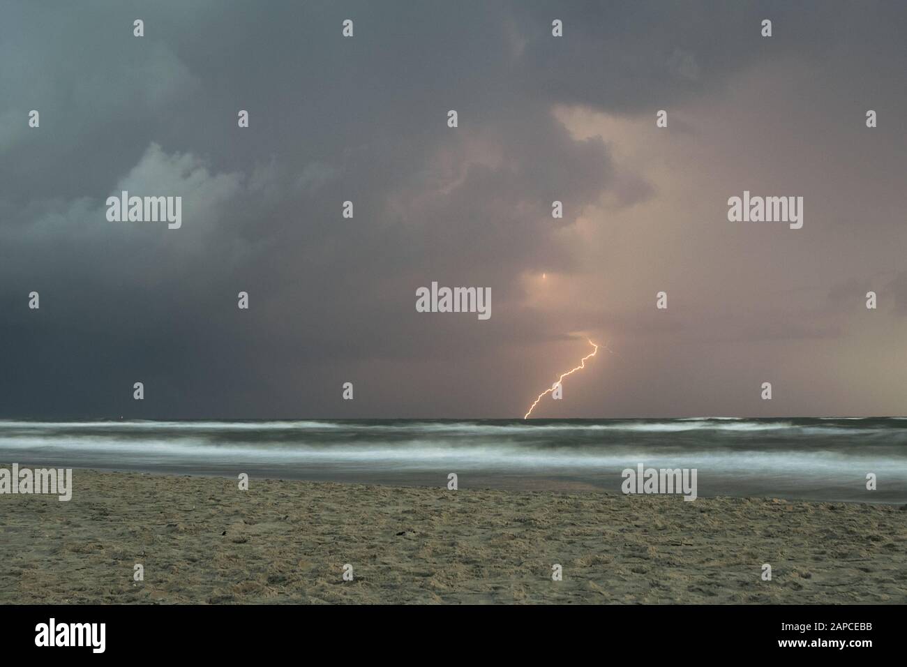 Lightning bolt strikes in the water from a thunderstorm over sea Stock ...