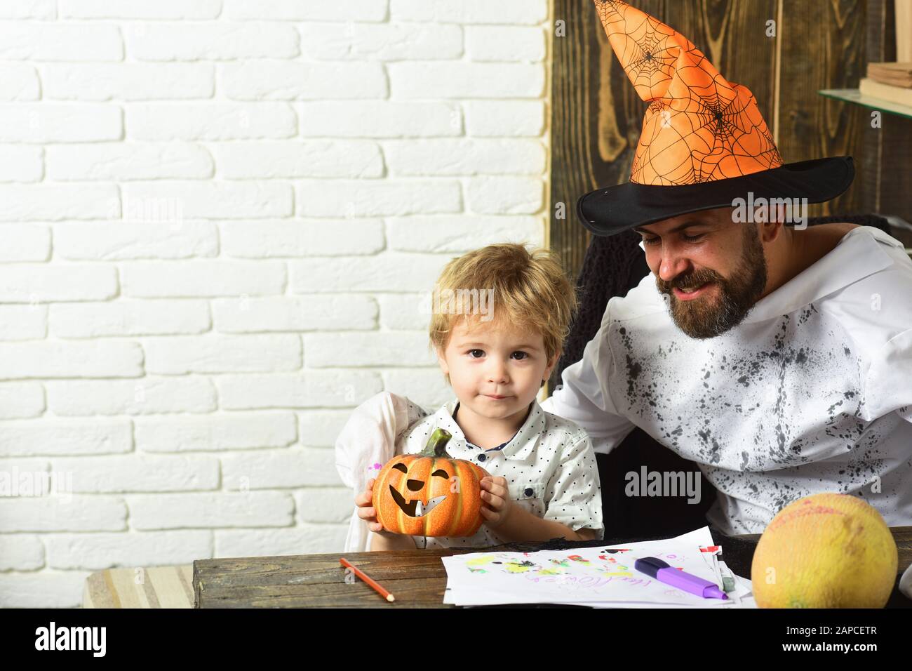 Halloween and holiday concept. Witcher and little magician make ...