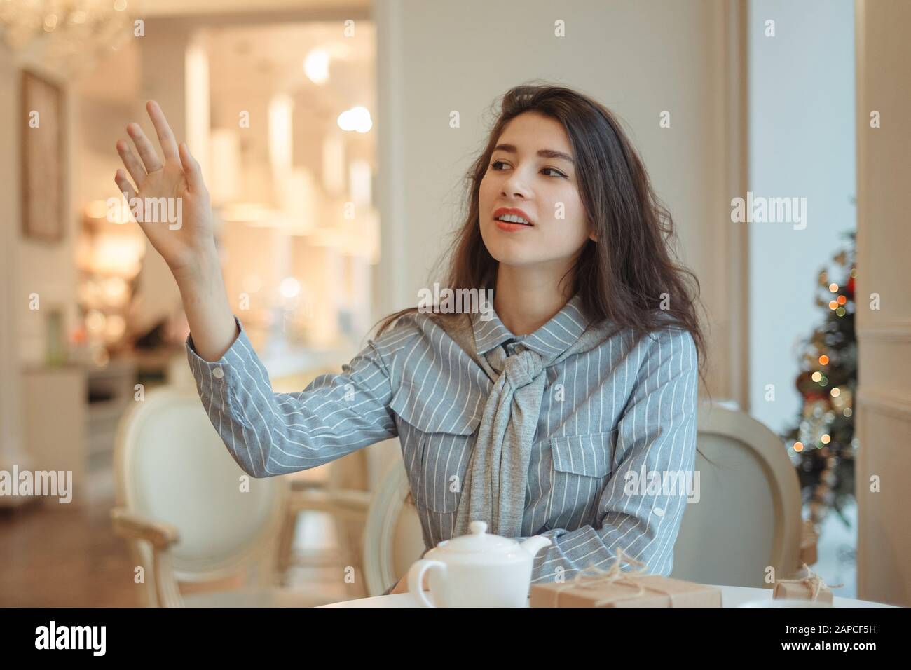 Young women calling the waitress Stock Photo - Alamy