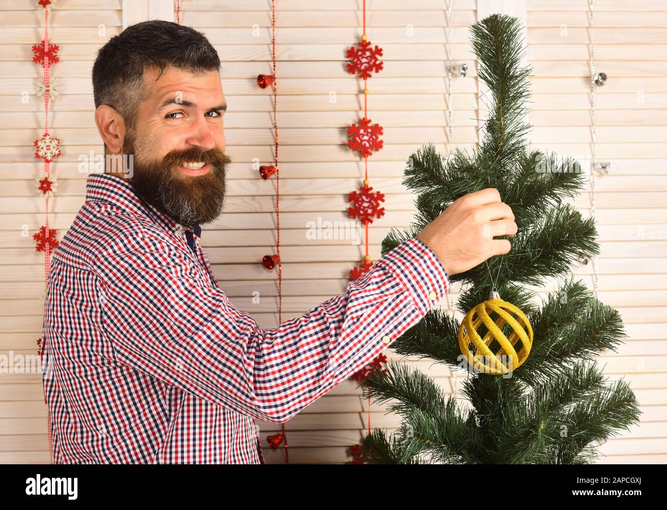 Guy decorates Christmas tree. Santa Claus in modern style with smiling ...