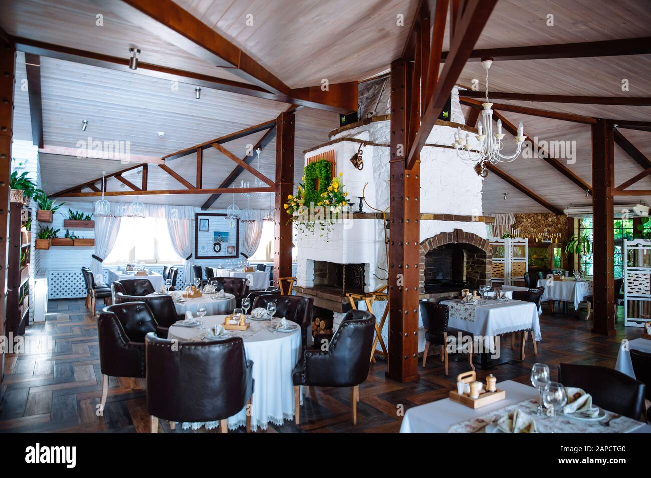 Restaurant interior with a stone stove in the middle of the hall. In ...