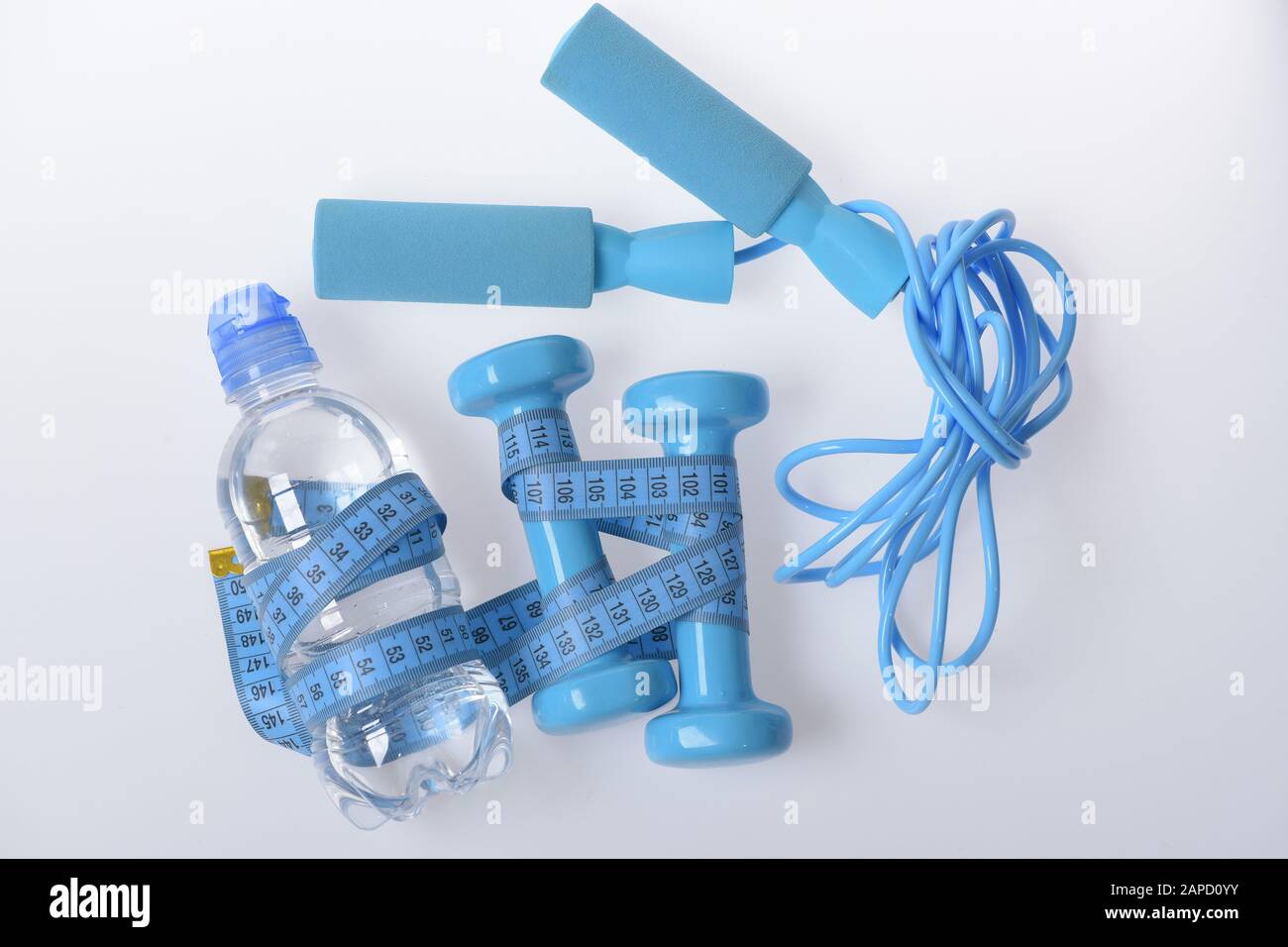 Dumbbells, skipping rope in cyan color near water bottle on white ...