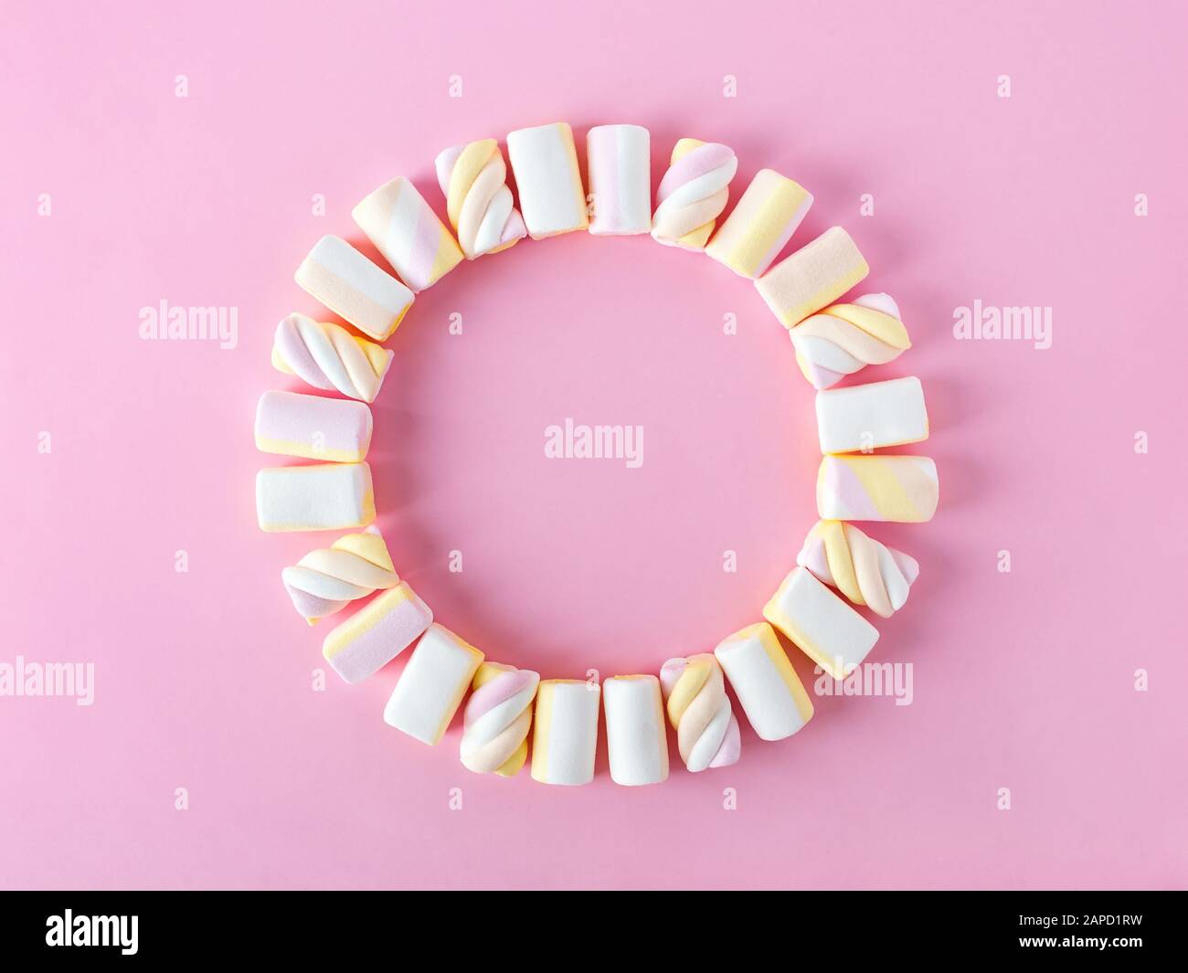 Round frame of sweet multicolored marshmallows on a pastel pink ...