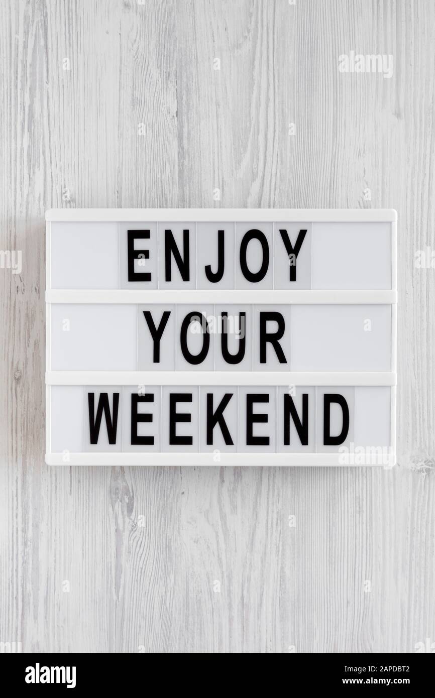 'Enjoy your weekend' words on a lightbox on a white wooden surface, top ...