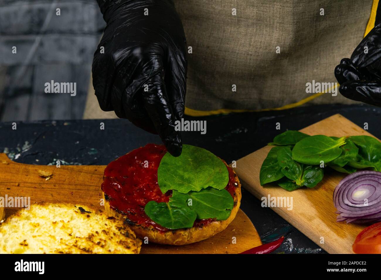 Process of cooking burgers. Cropeed view of chef hands in black gloves ...