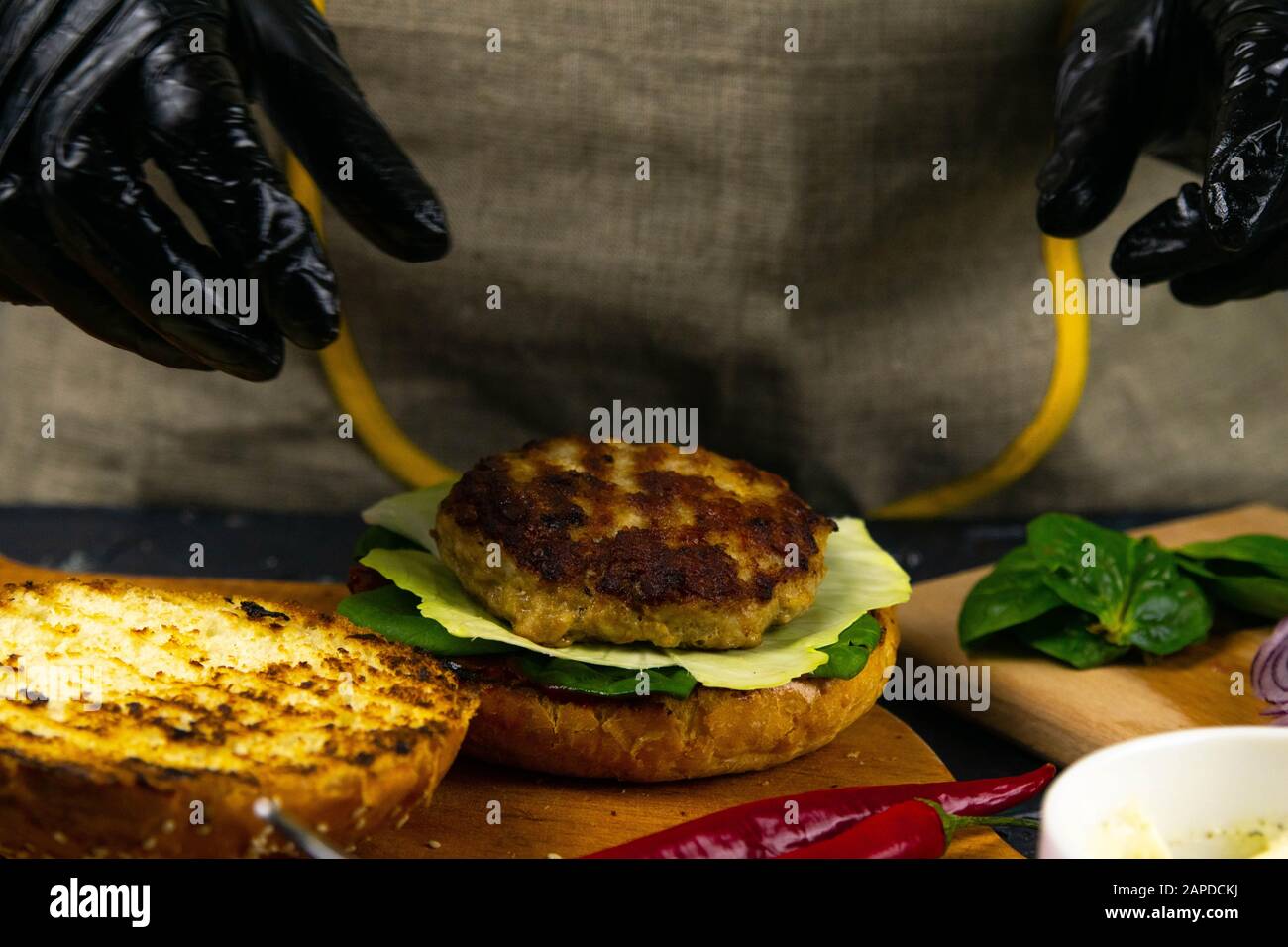 Process of cooking burgers. Cropeed view of chef hands in black gloves ...