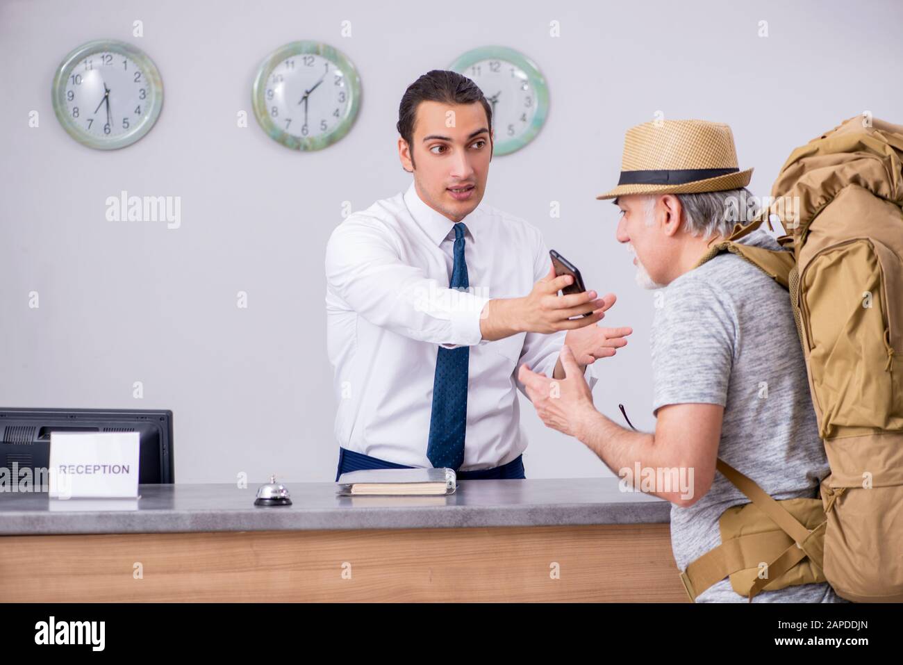 Old backpacker at the hotel reception Stock Photo - Alamy