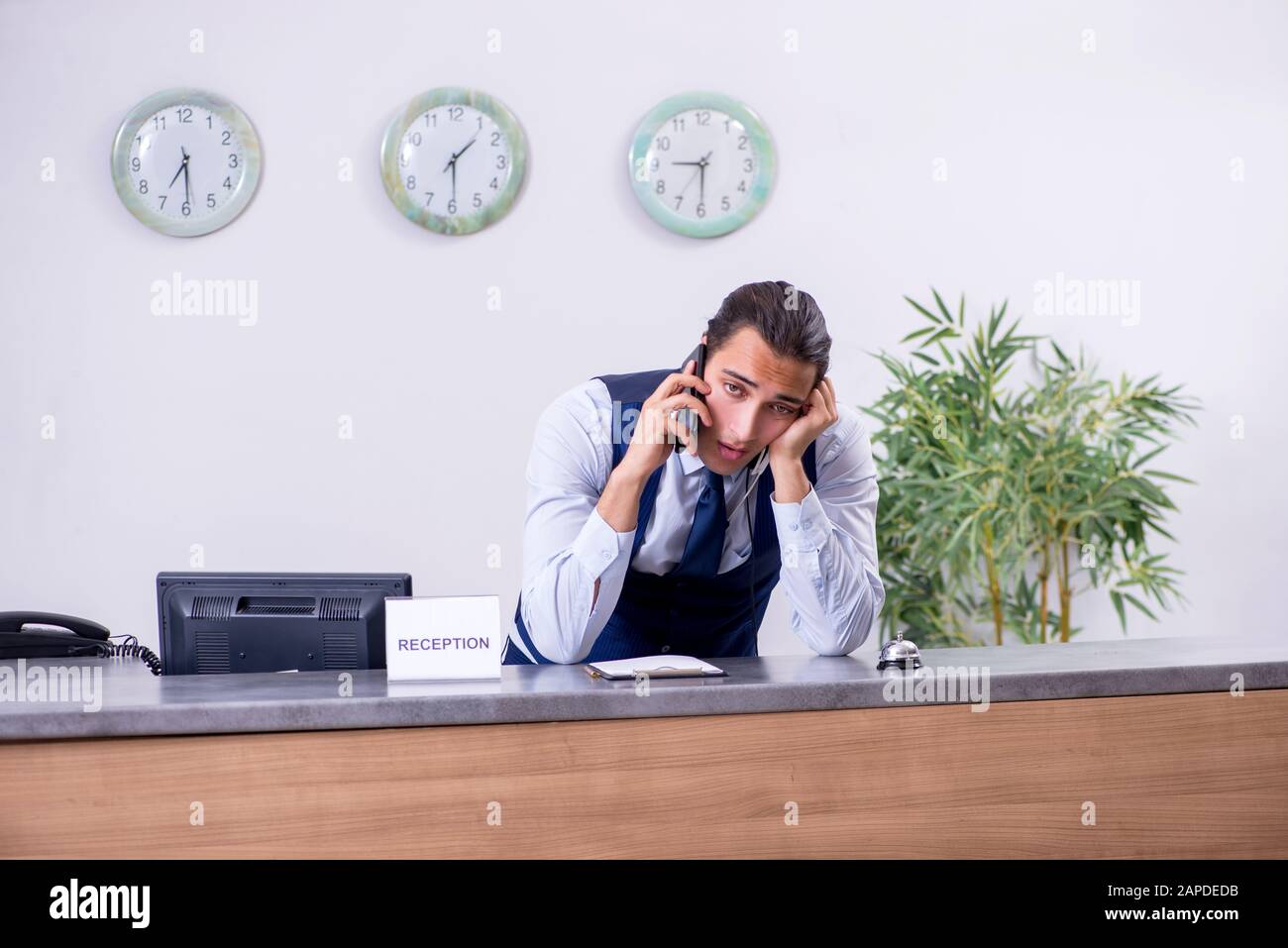 The young man receptionist at the hotel counter Stock Photo - Alamy