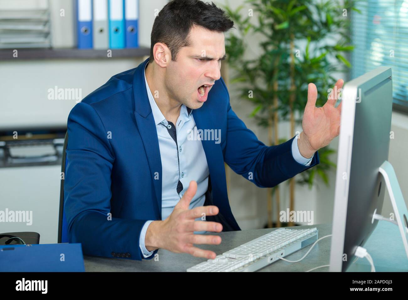 suited man at office desk shouting at computer Stock Photo - Alamy