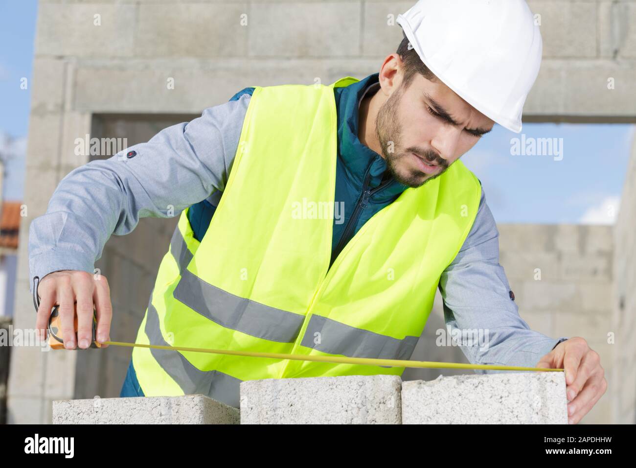 a bricklayer measures a wall Stock Photo - Alamy