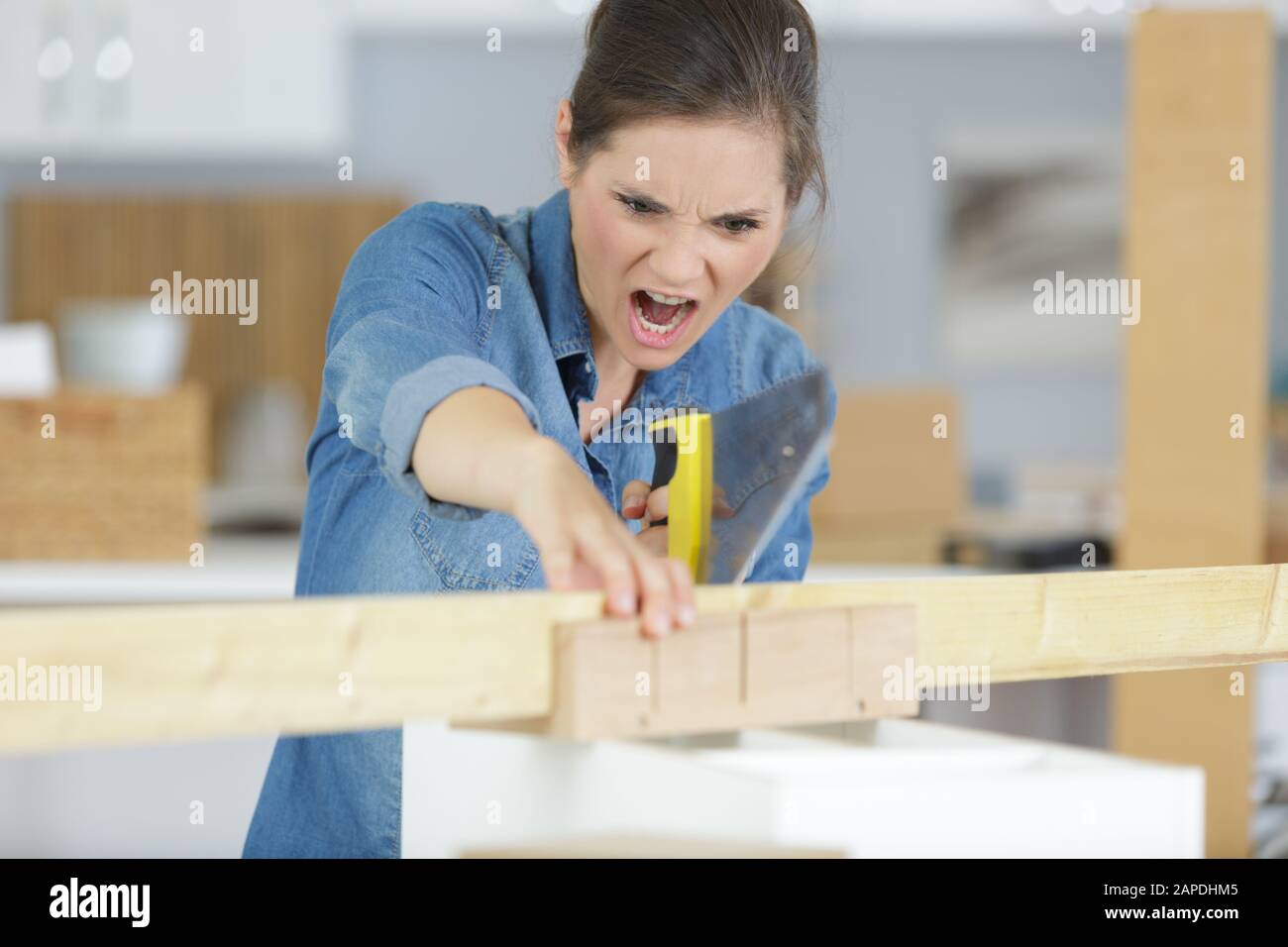 portrait of an angry woman cutting wood Stock Photo - Alamy