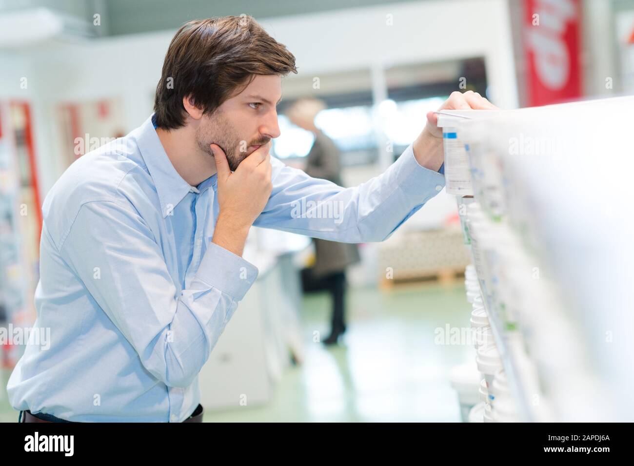 man buying paint in tool store Stock Photo - Alamy