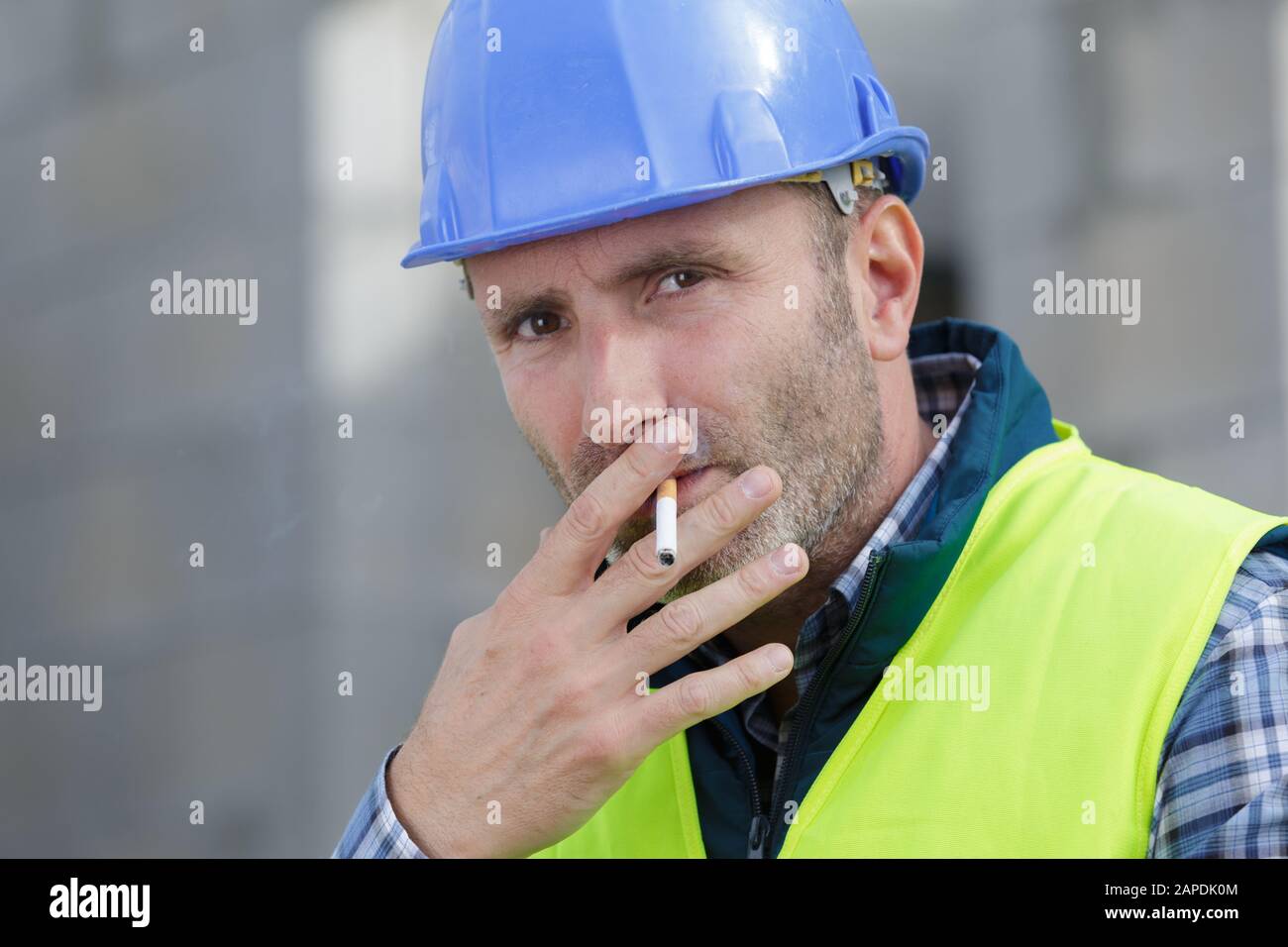 happy builder smoking cigarette outdoors Stock Photo - Alamy
