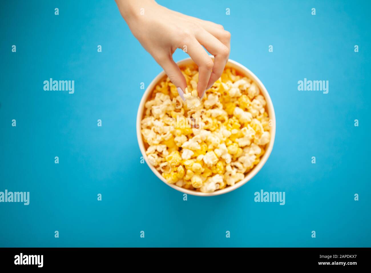 Food. Woman Hand that Takes Popcorn from Bucket. Popcorn Bucket on Blue ...