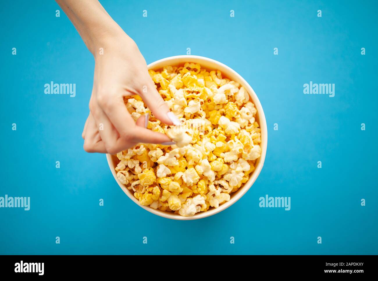 Food. Woman Hand that Takes Popcorn from Bucket. Popcorn Bucket on Blue ...