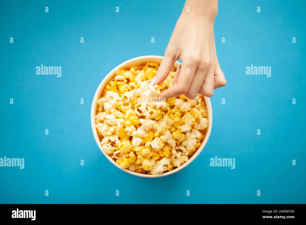Food. Woman Hand that Takes Popcorn from Bucket. Popcorn Bucket on Blue ...