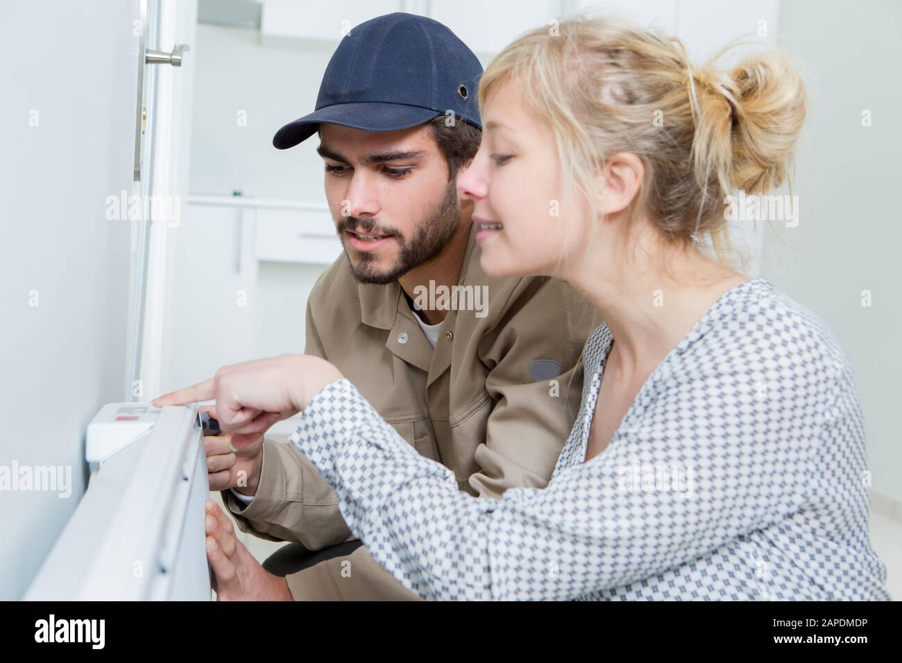 female customer watching male plumber work Stock Photo - Alamy