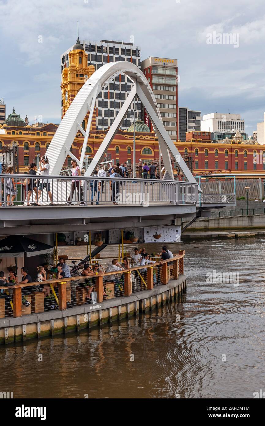The Southgate Pedestrian Bridge is busy with people walking over it to ...