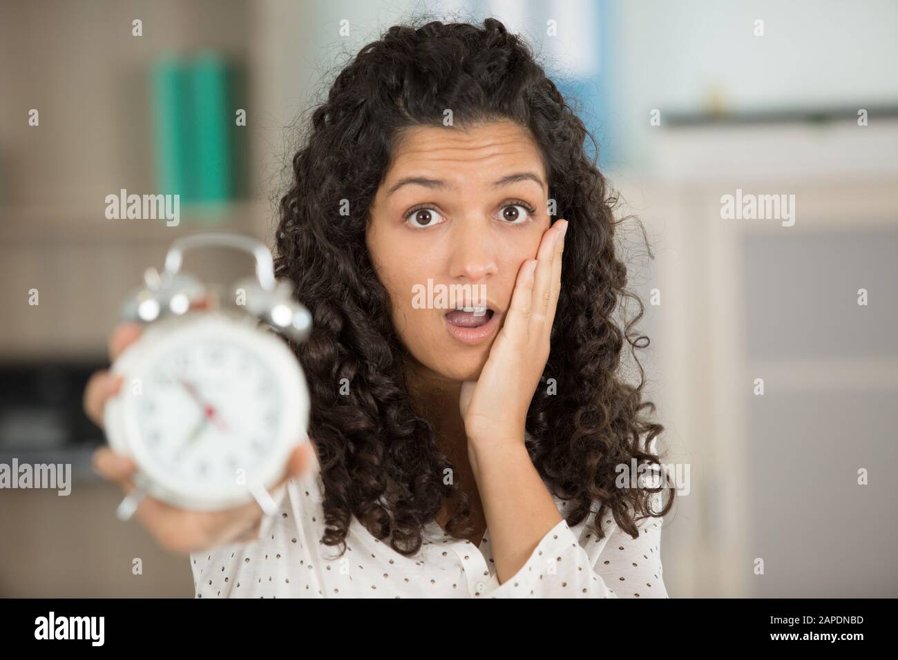 young upset woman student holding alarm clock Stock Photo - Alamy