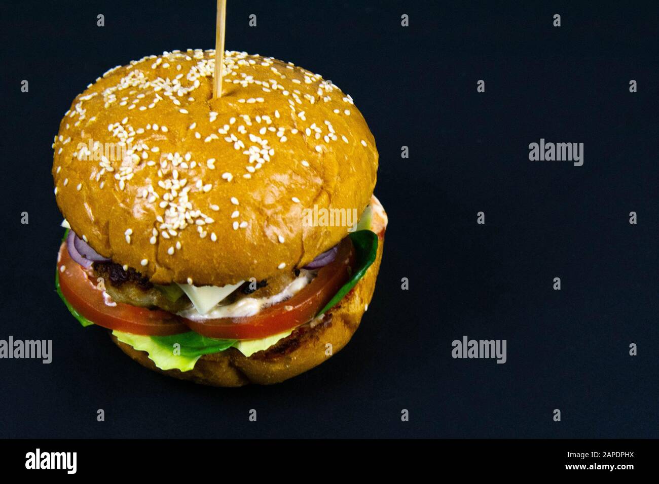 Fresh tasty burger on black background front views Stock Photo - Alamy