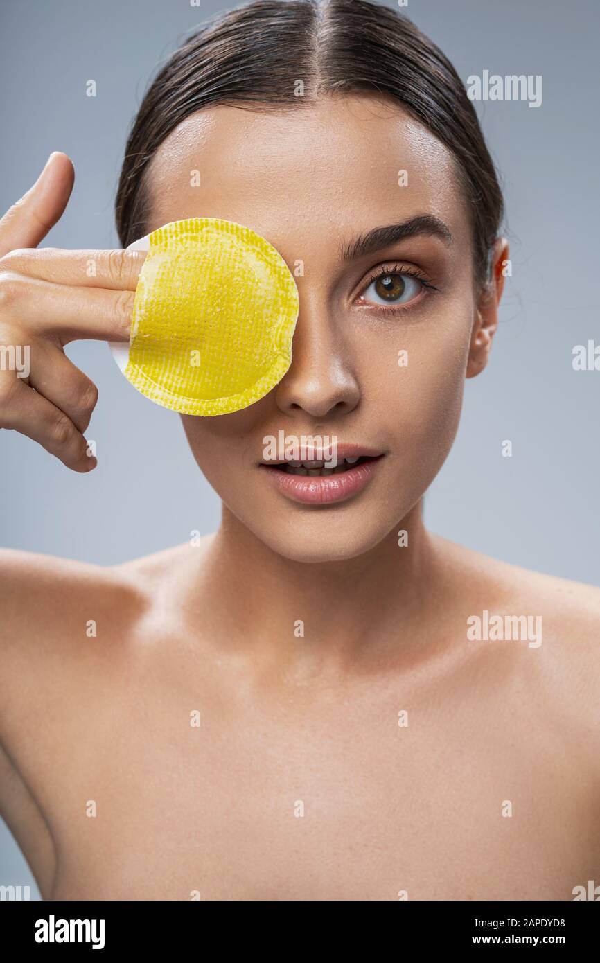 Beautiful girl cleansing her face against grey background Stock Photo ...