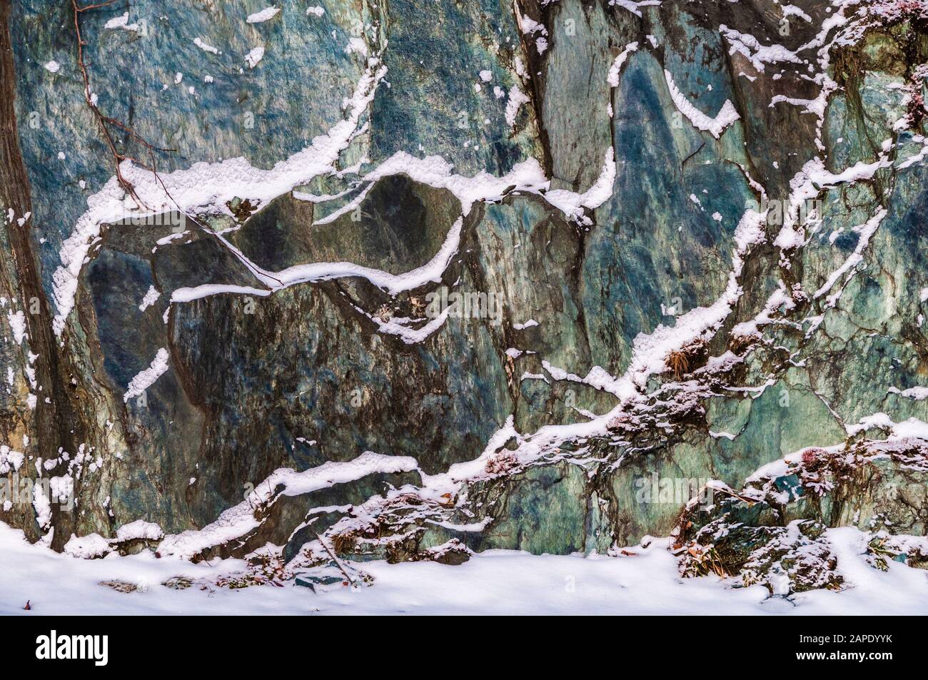 Colorful rock wall with snow on the ledges Stock Photo - Alamy