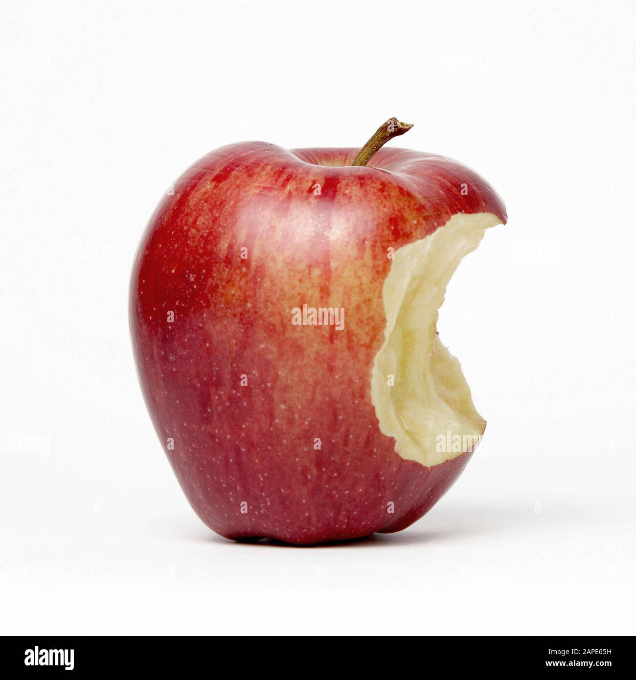 A closeup shot of a half-eaten apple on a white surface Stock Photo - Alamy