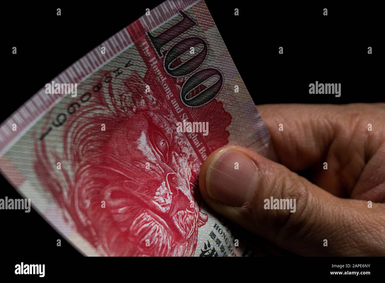 Closeup shot of a 100 Hong Kong dollar bill in front of a black ...