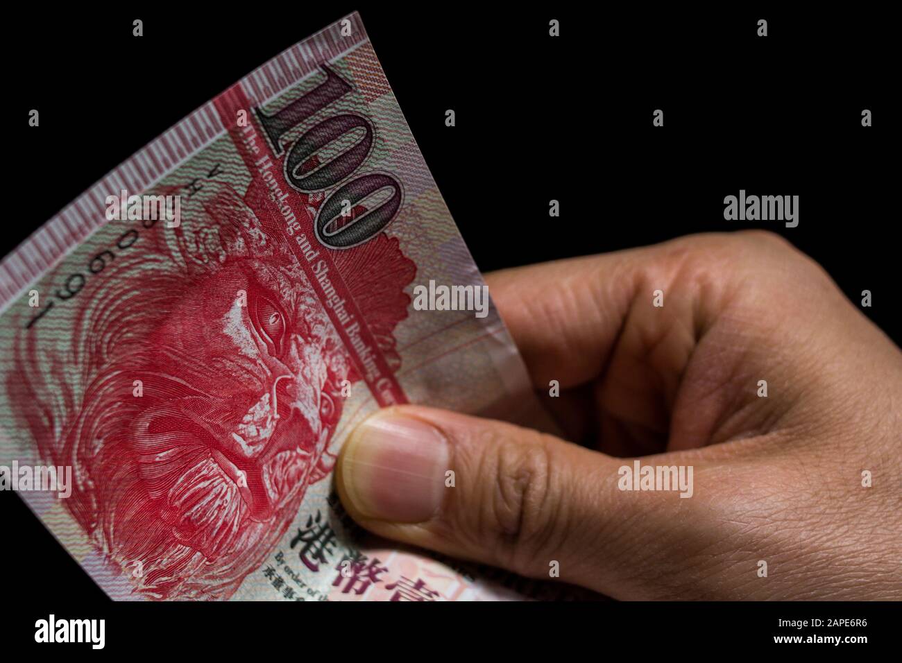 Closeup shot of a 100 Hong Kong dollar bill in front of a black ...