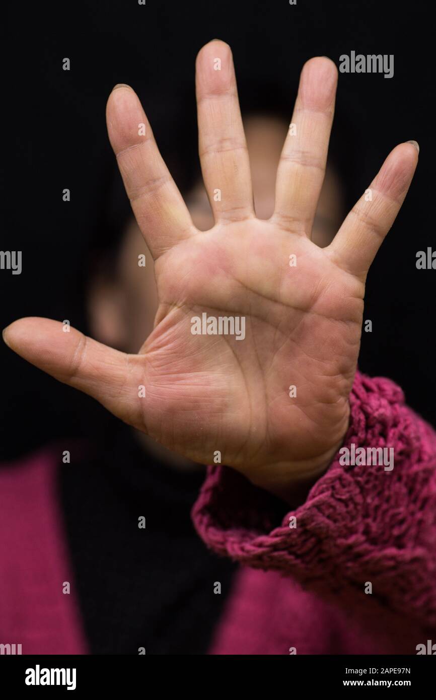 Vertical shot of a Chinese female closing her face with her hand-women ...