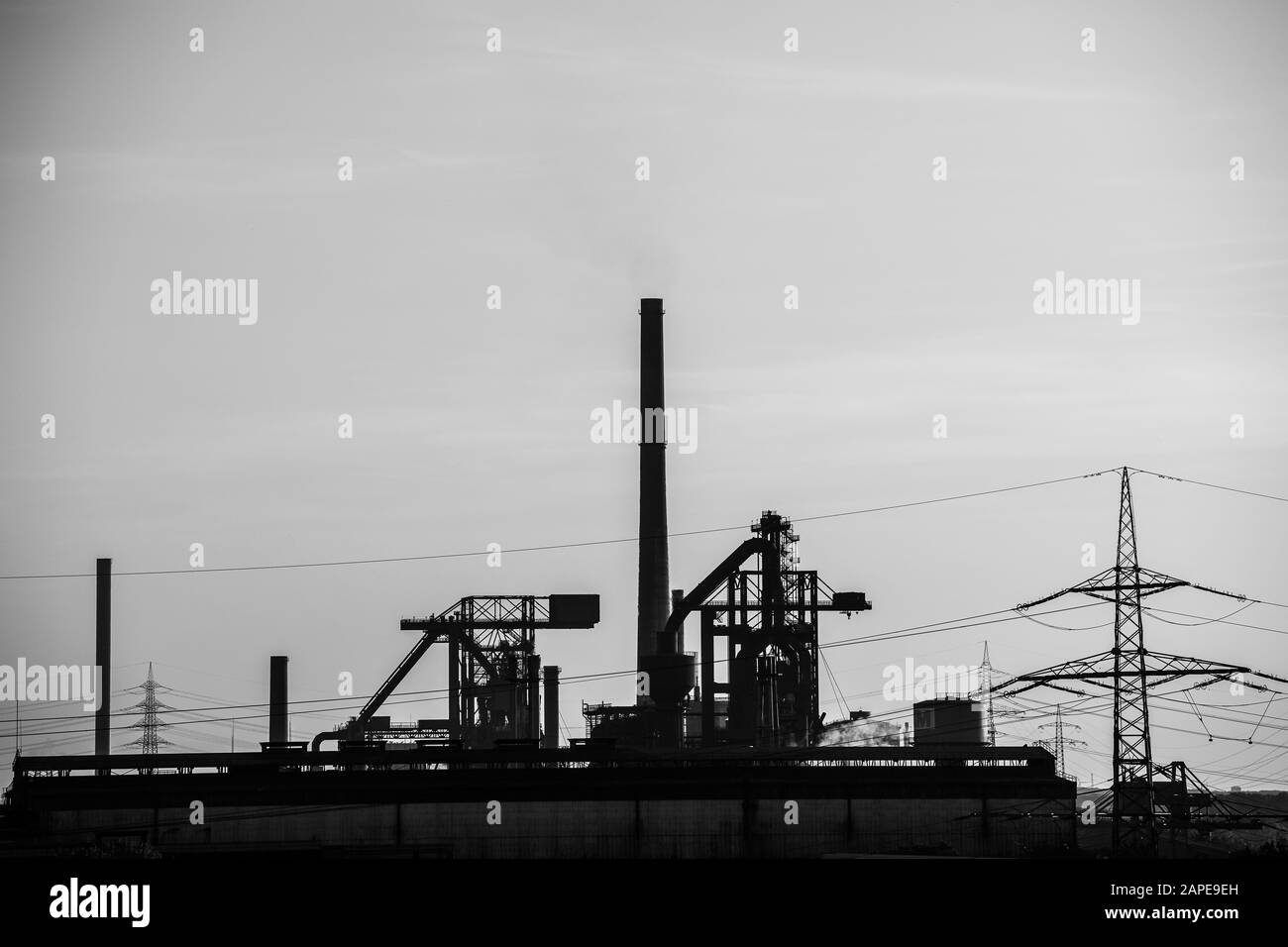 Grayscale shot of factory buildings with a cloudy sky in the background ...