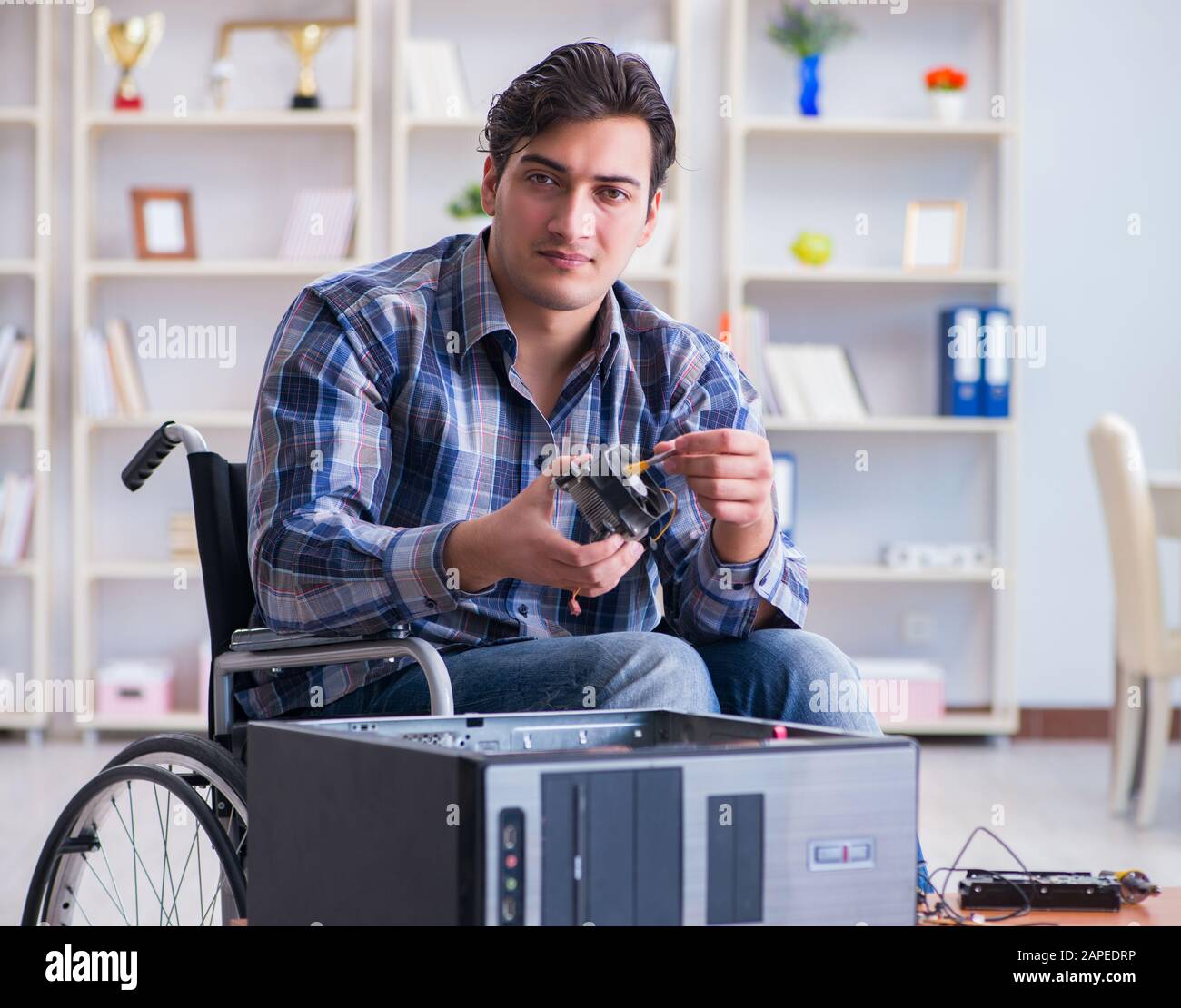 The disabled man on wheelchair repairing computer Stock Photo - Alamy