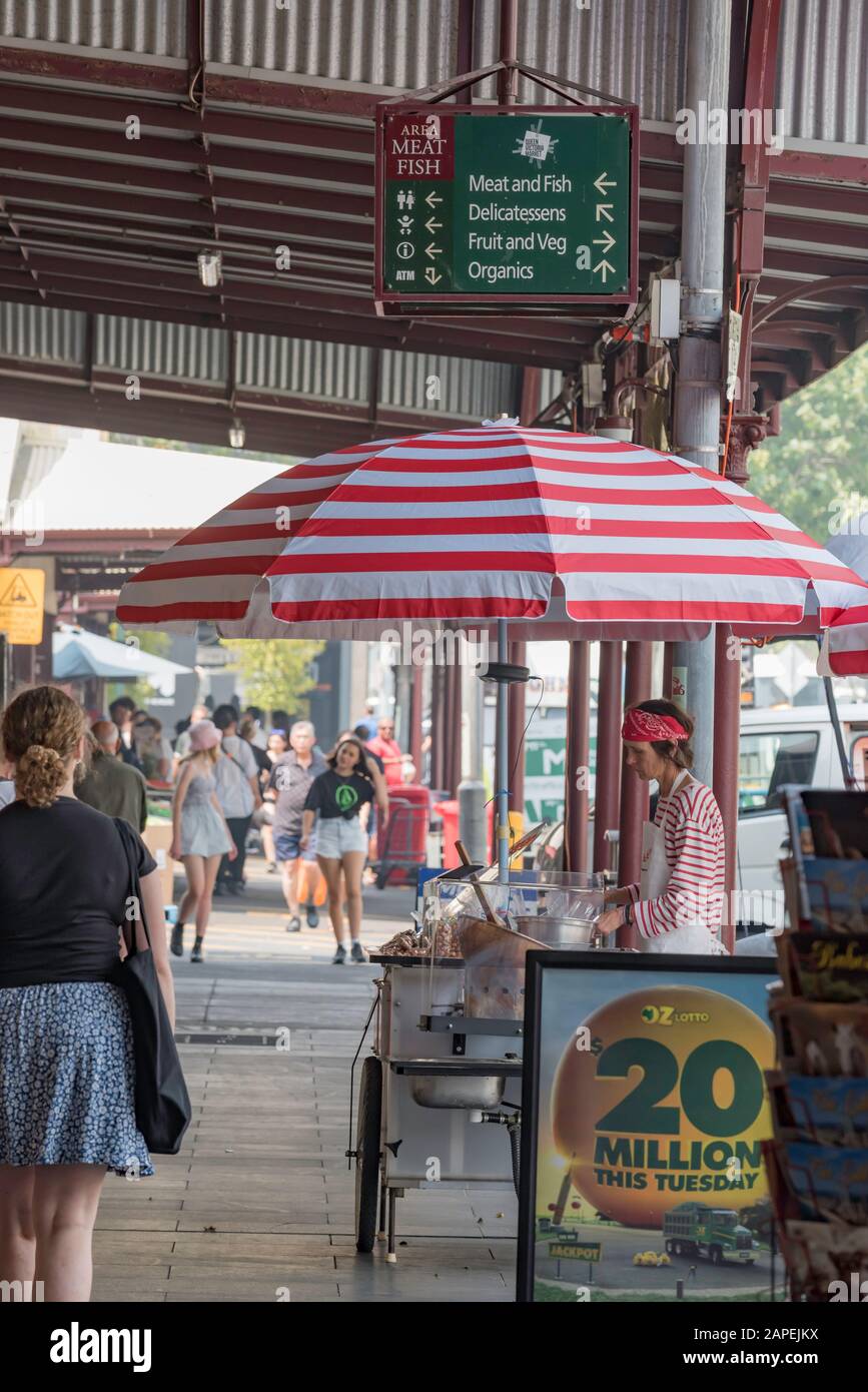 A woman cooking and selling roasted chestnuts at the outdoor section of ...