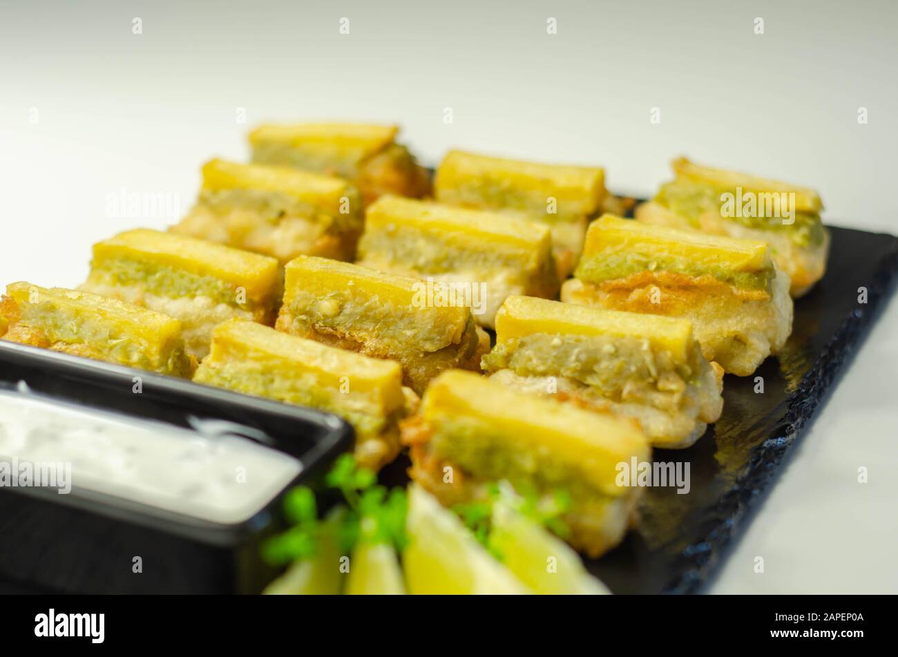 Skinless and boneless battered Alaska Pollock fillet pieces, topped ...