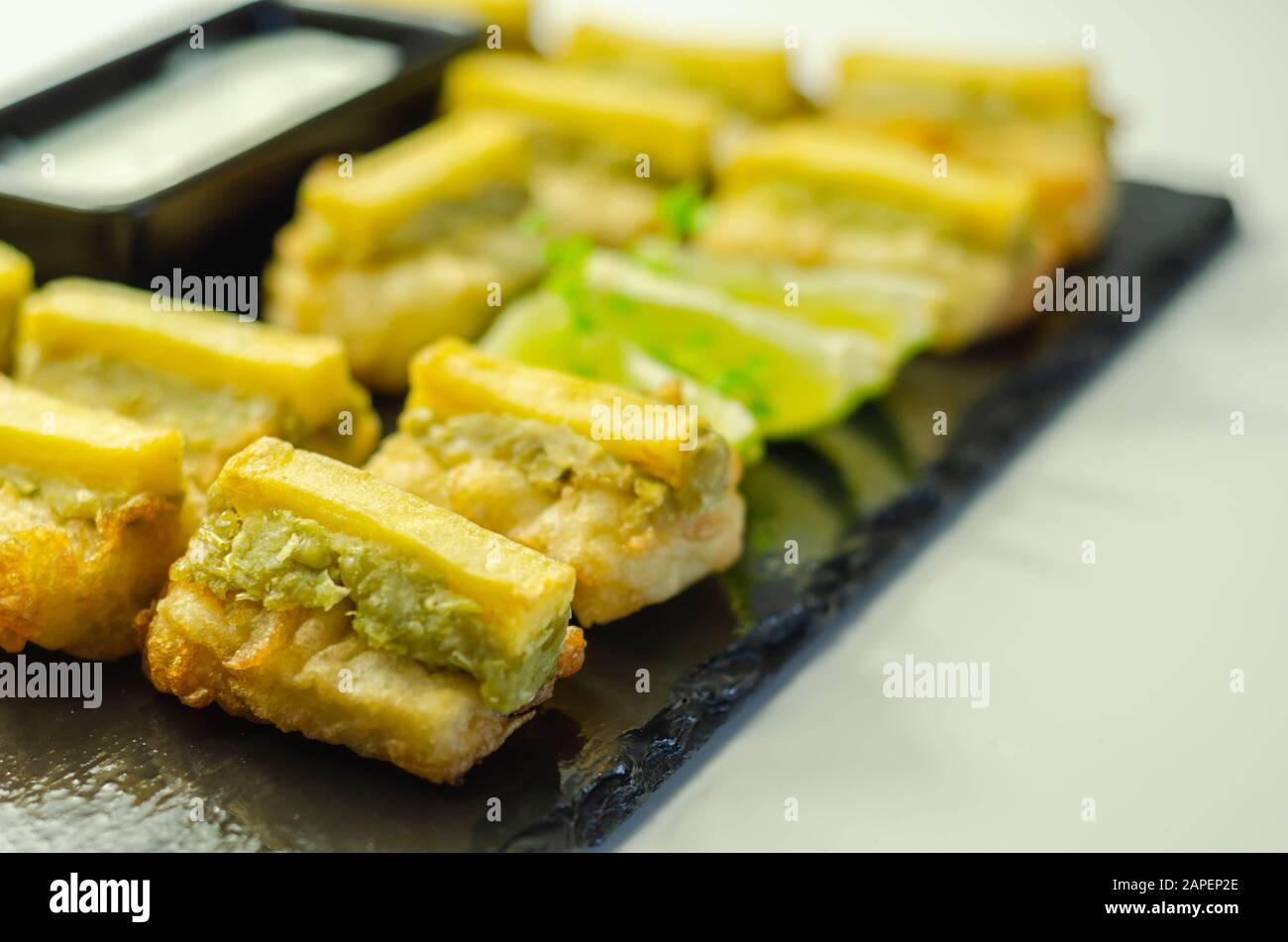 Skinless and boneless battered Alaska Pollock fillet pieces, topped ...