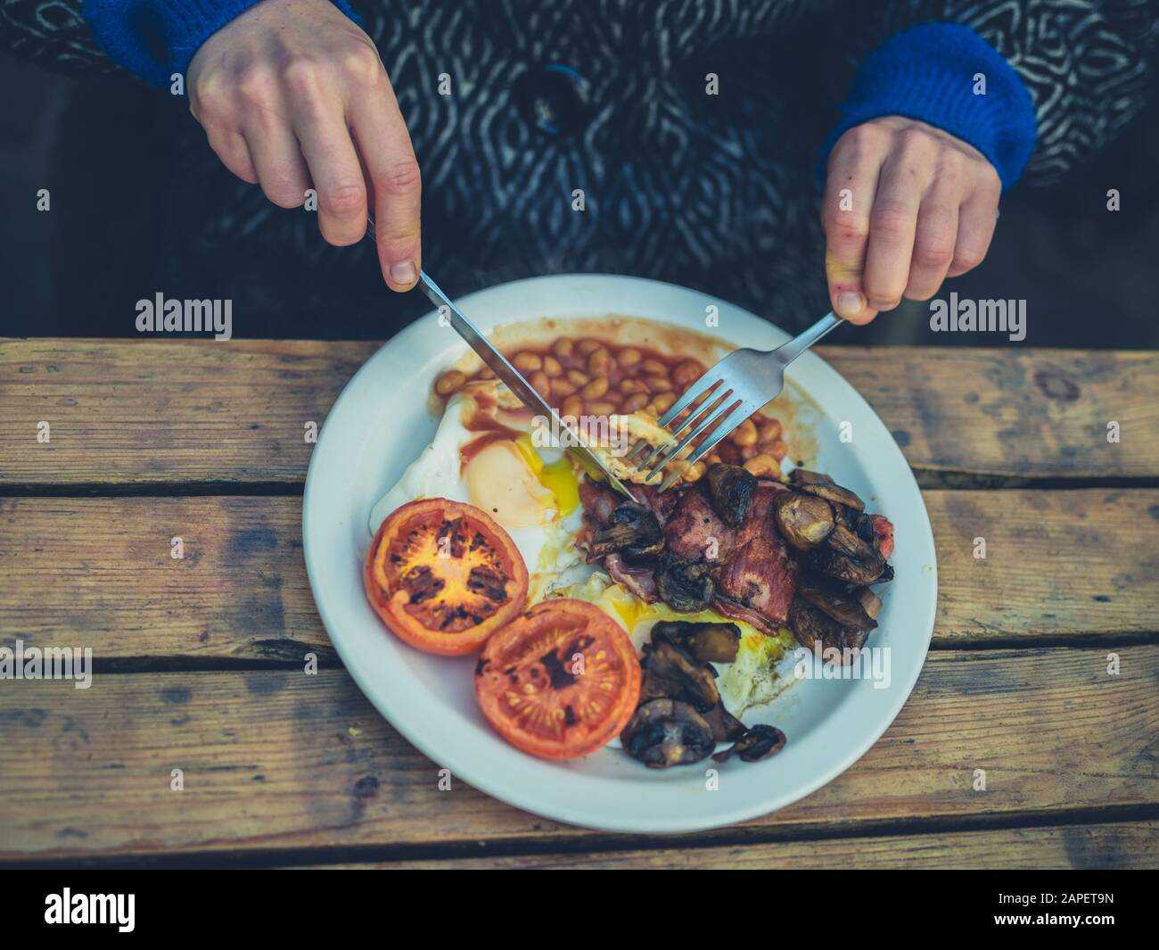 A young woman is eating a traditional english breakfast in a cafe Stock ...