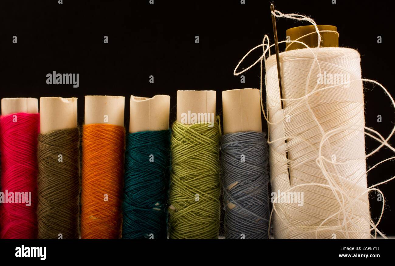 Colorful cotton yarns on rolls for sewing. Thread spools used in fabric ...