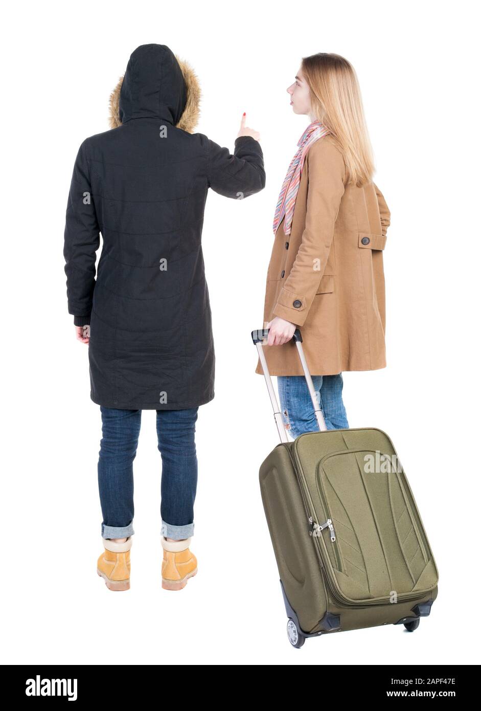 Back view of two woman in winter jacket traveling with suitcas. Back ...