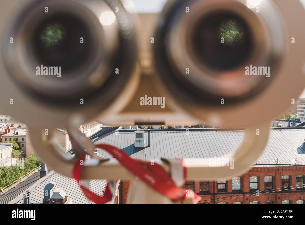 stationary binocular on the lookout point at city roofs. All lit up by ...