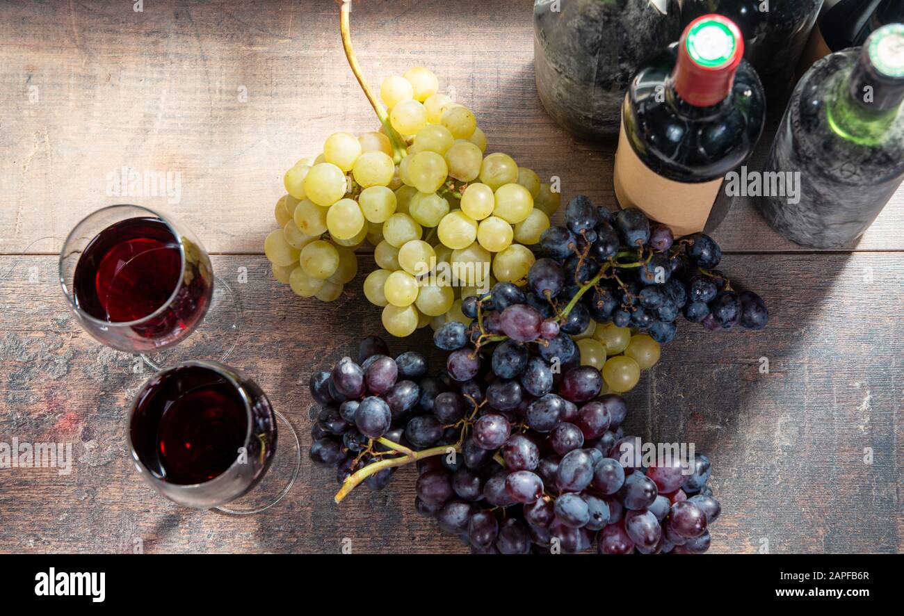 two wineglasses, red and white grapes with bottles of a red wine Stock ...