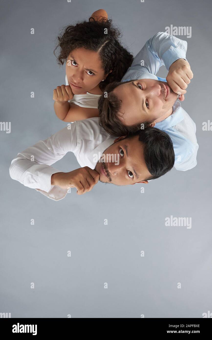 Group of young people looking up above top view in studio background ...